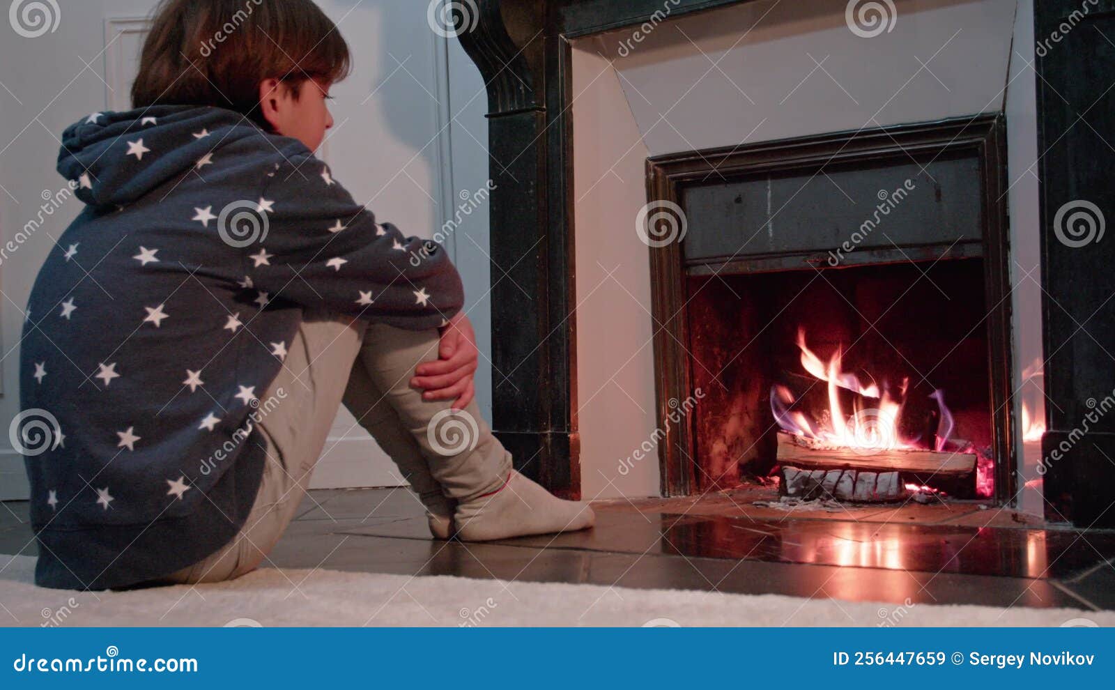 Young Boy Sit in Front of Fireplace Looking at Fire Getting Warm Stock ...