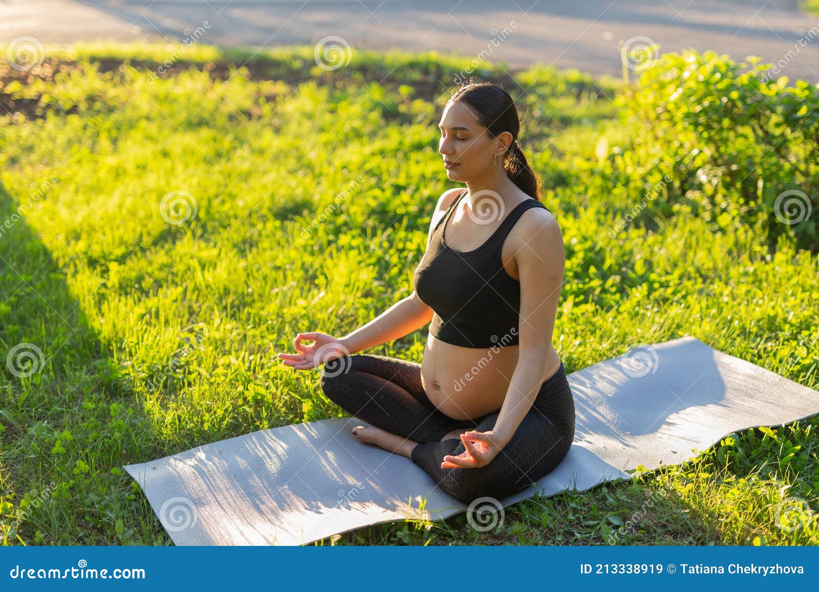 Cute Young Caucasian Pregnant Woman Is Meditating While Sitting On A