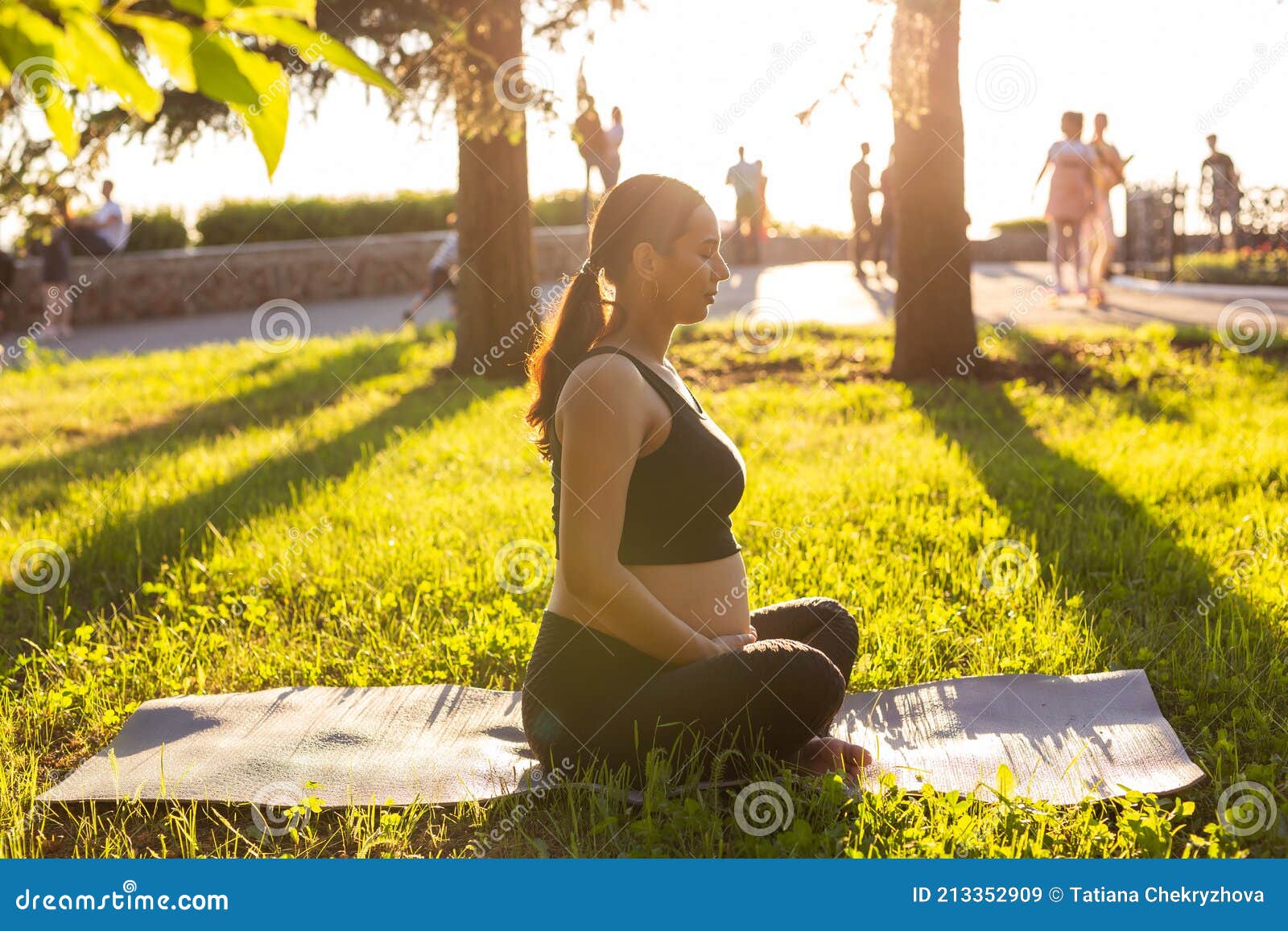 Cute Young Caucasian Pregnant Woman Is Meditating While Sitting On A