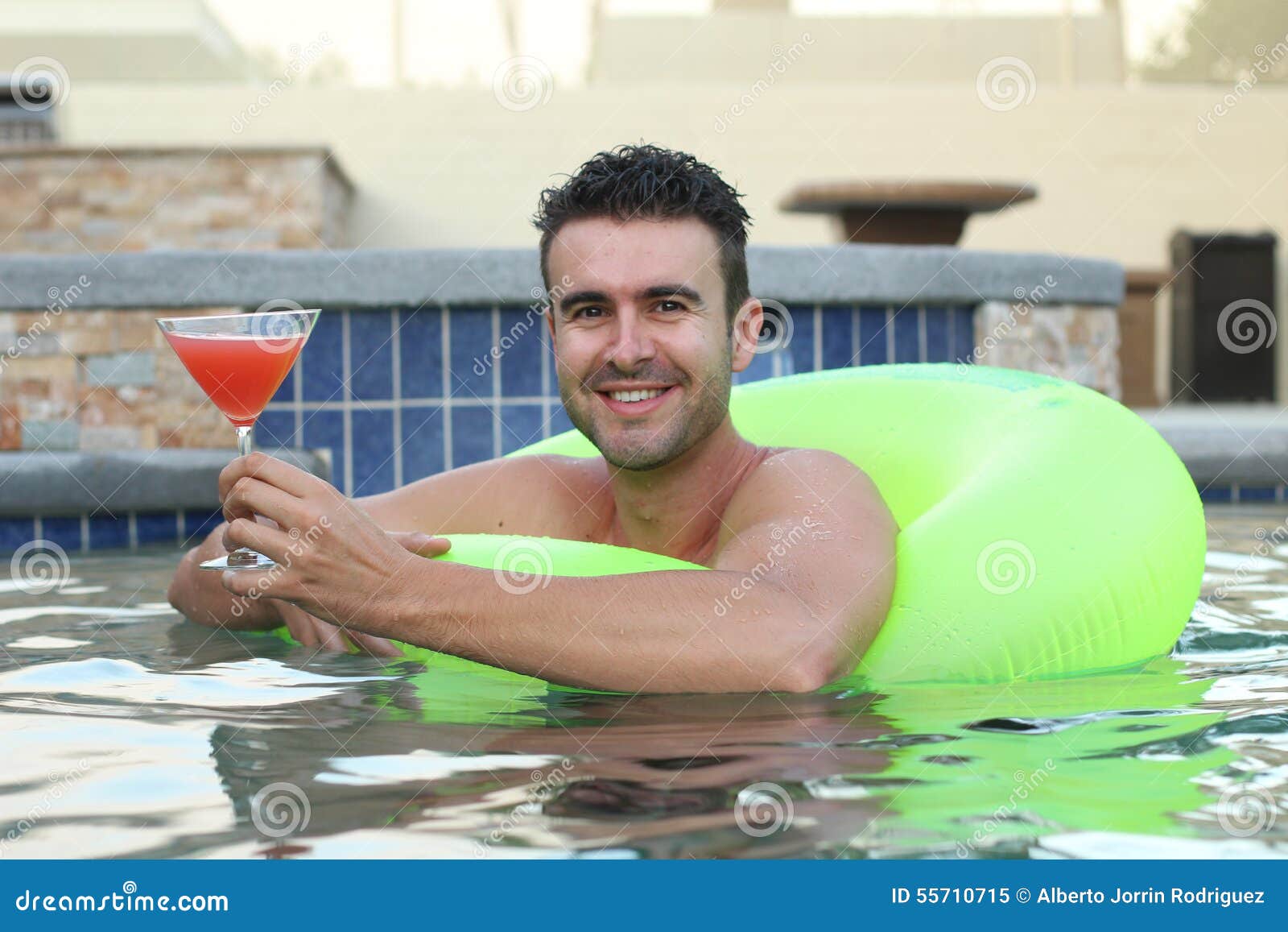 Cute Young Man Drinking A Cocktail While Relaxing In A Swimming Pool ...