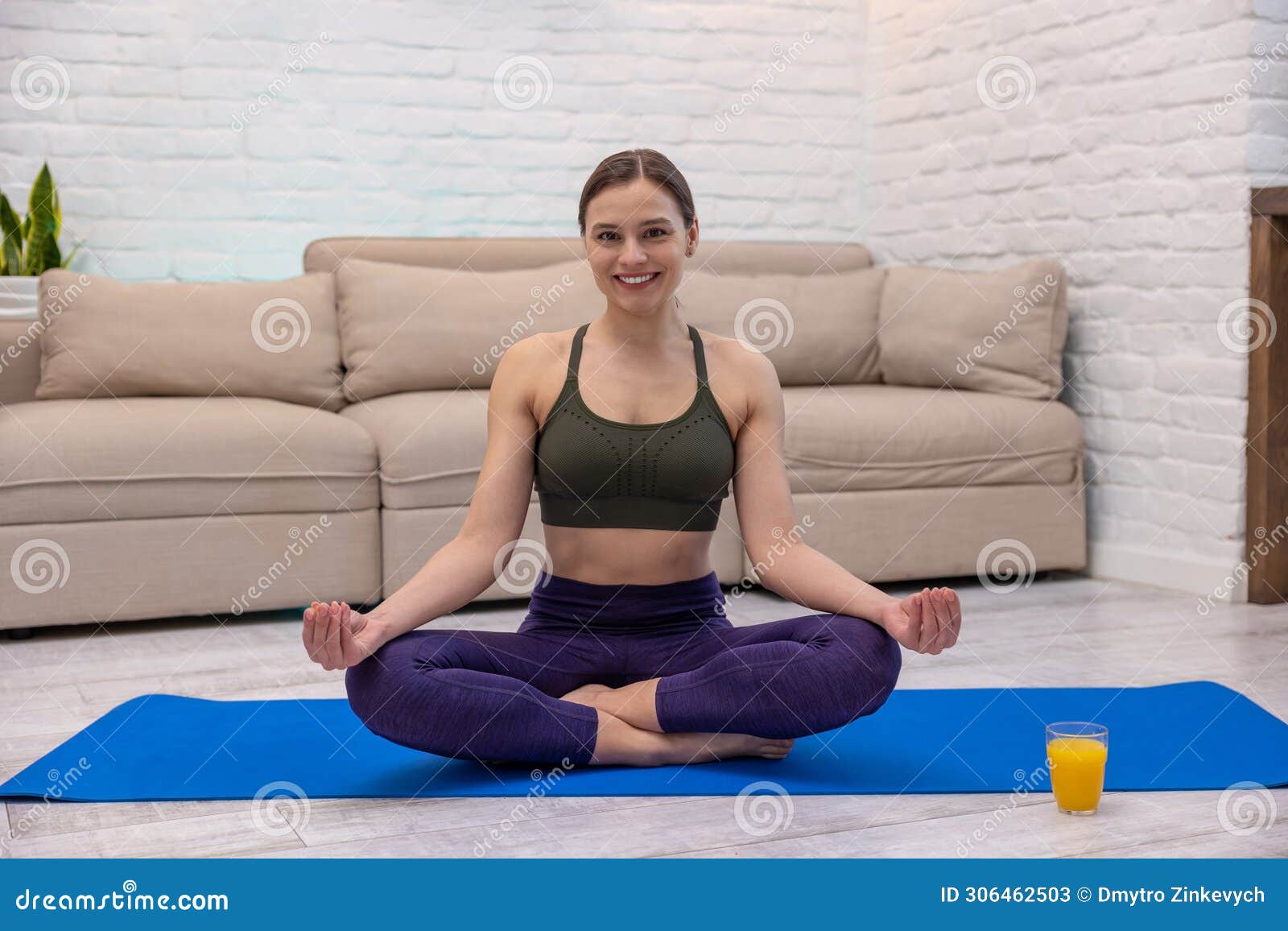 Cute Young Woman Sitting In A Lotus Pose And Looking Peaceful Stock