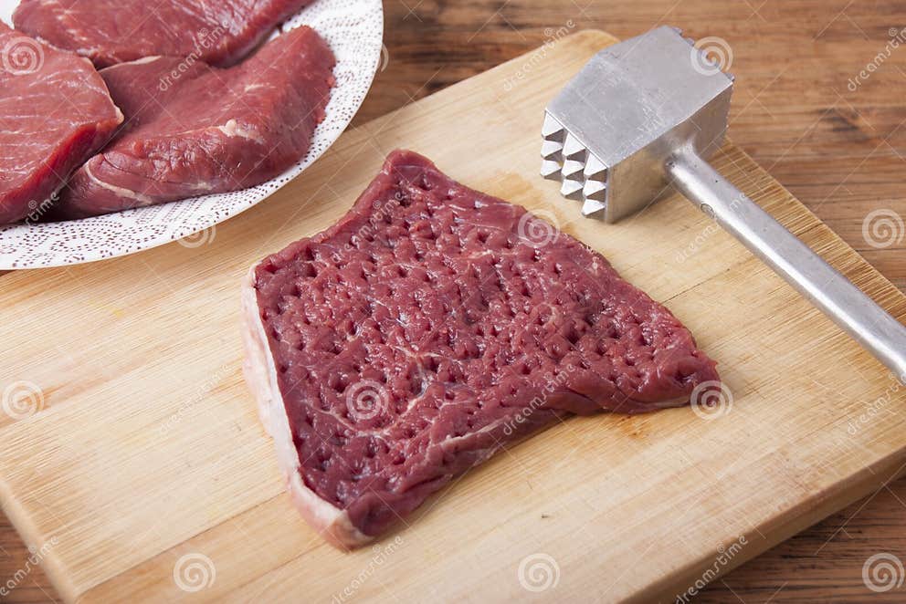 On a Cutting Board Raw Beef Meat with a Hammer for Beating Meat Stock ...