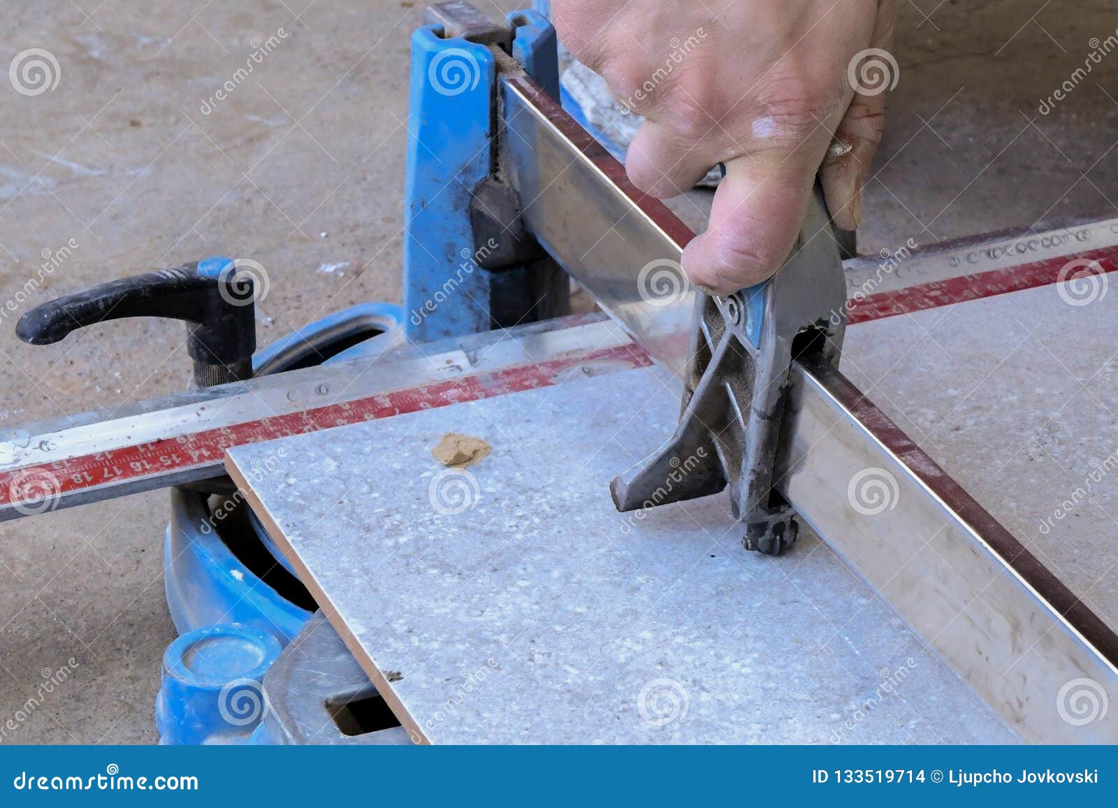 Worker Placing a Big Ceramic Tile in a Cutter and Cutting Tile Stock ...