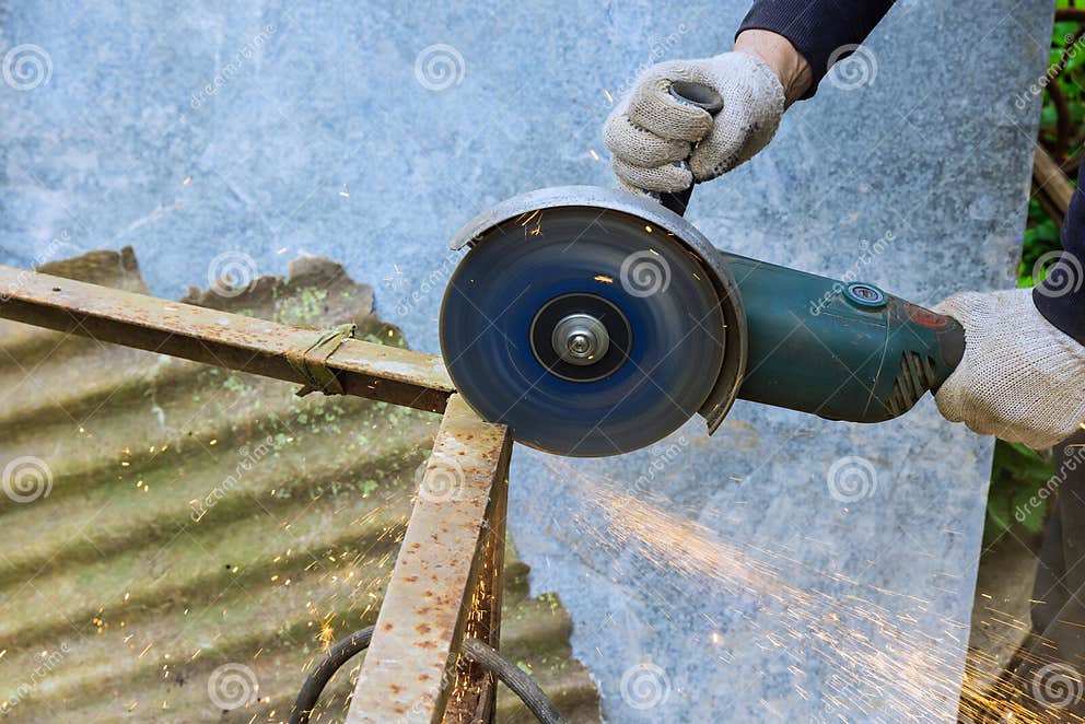 During Cutting of Metal Frames, a Worker Uses an Angle Grinder Hand Saw ...