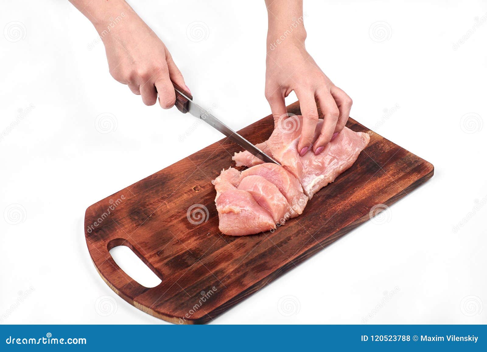 Cutting Raw Meat with a Kitchen Knife on a Cutting Board Isolated on ...