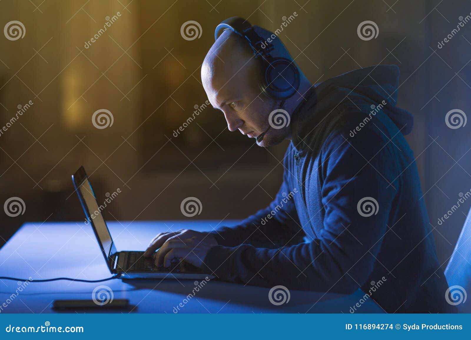 Hacker in Headset Typing on Laptop in Dark Room Stock Photo - Image of ...