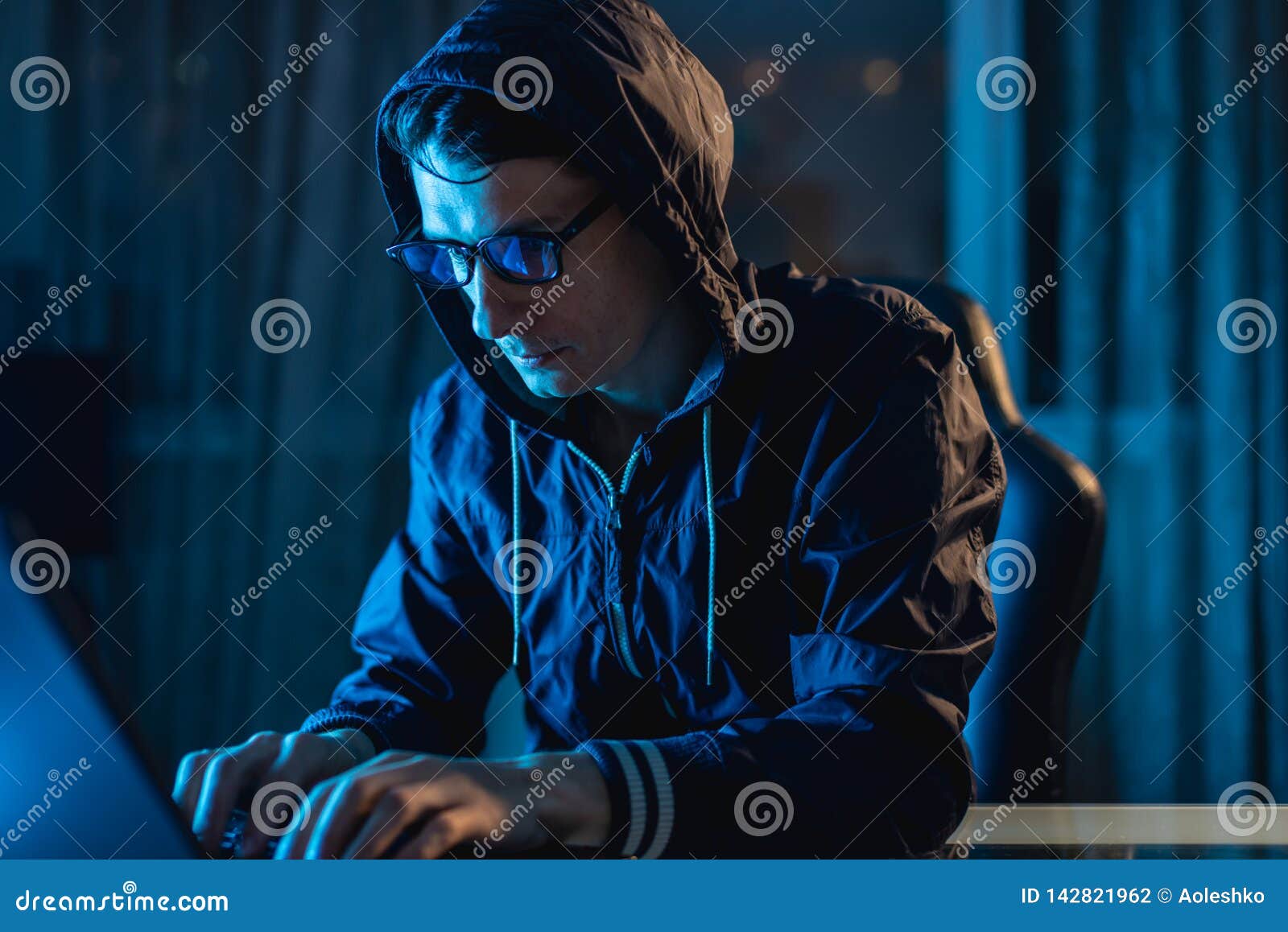 Cybercriminal Hacker In The Hood Typing Program Code While Stealing Access Databases With
