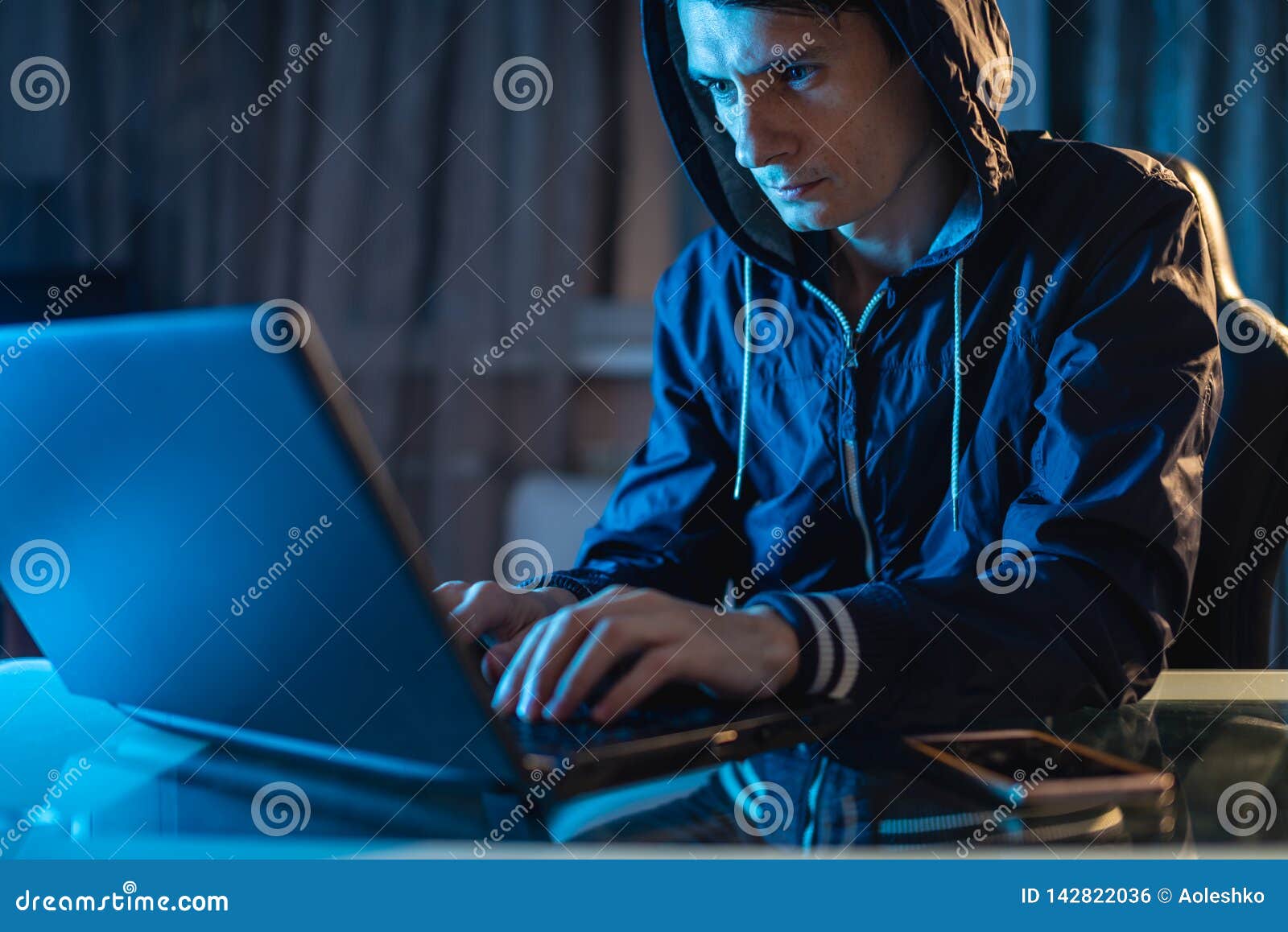 Cybercriminal Hacker In The Hood Typing Program Code While Stealing Access Databases With