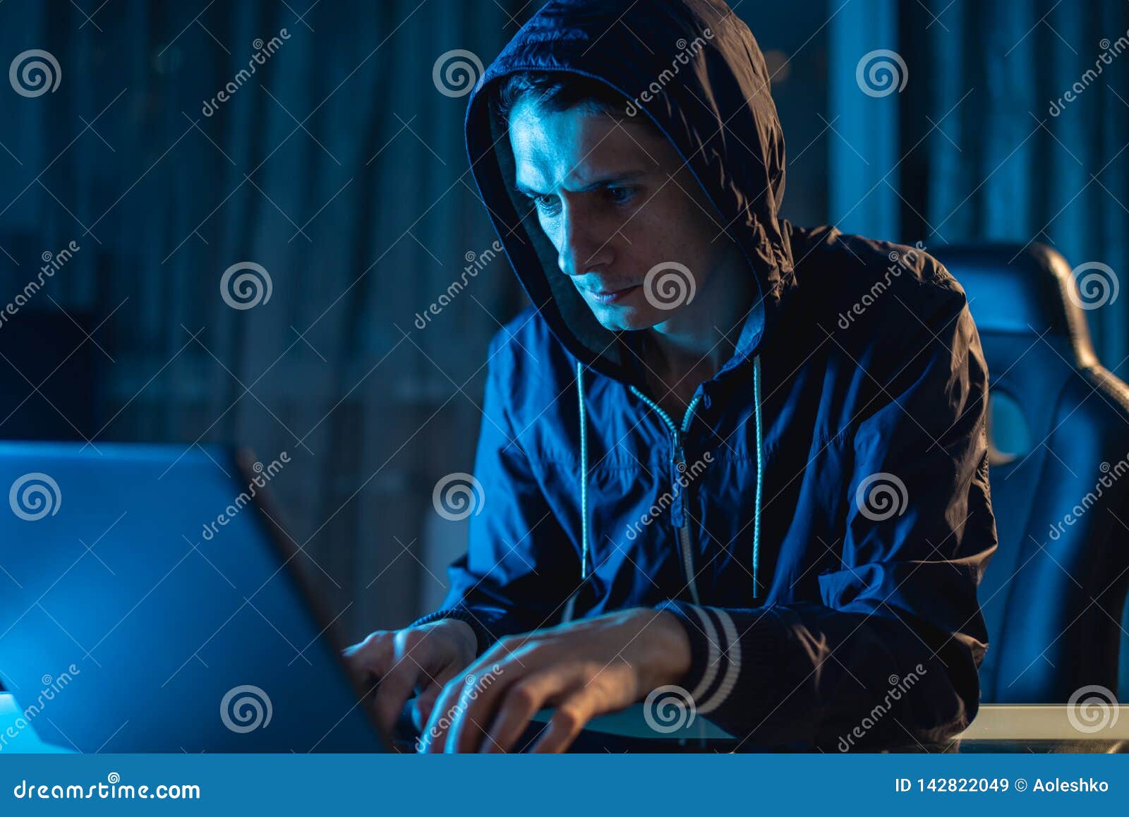 Cybercriminal Hacker In The Hood Typing Program Code While Stealing Access Databases With