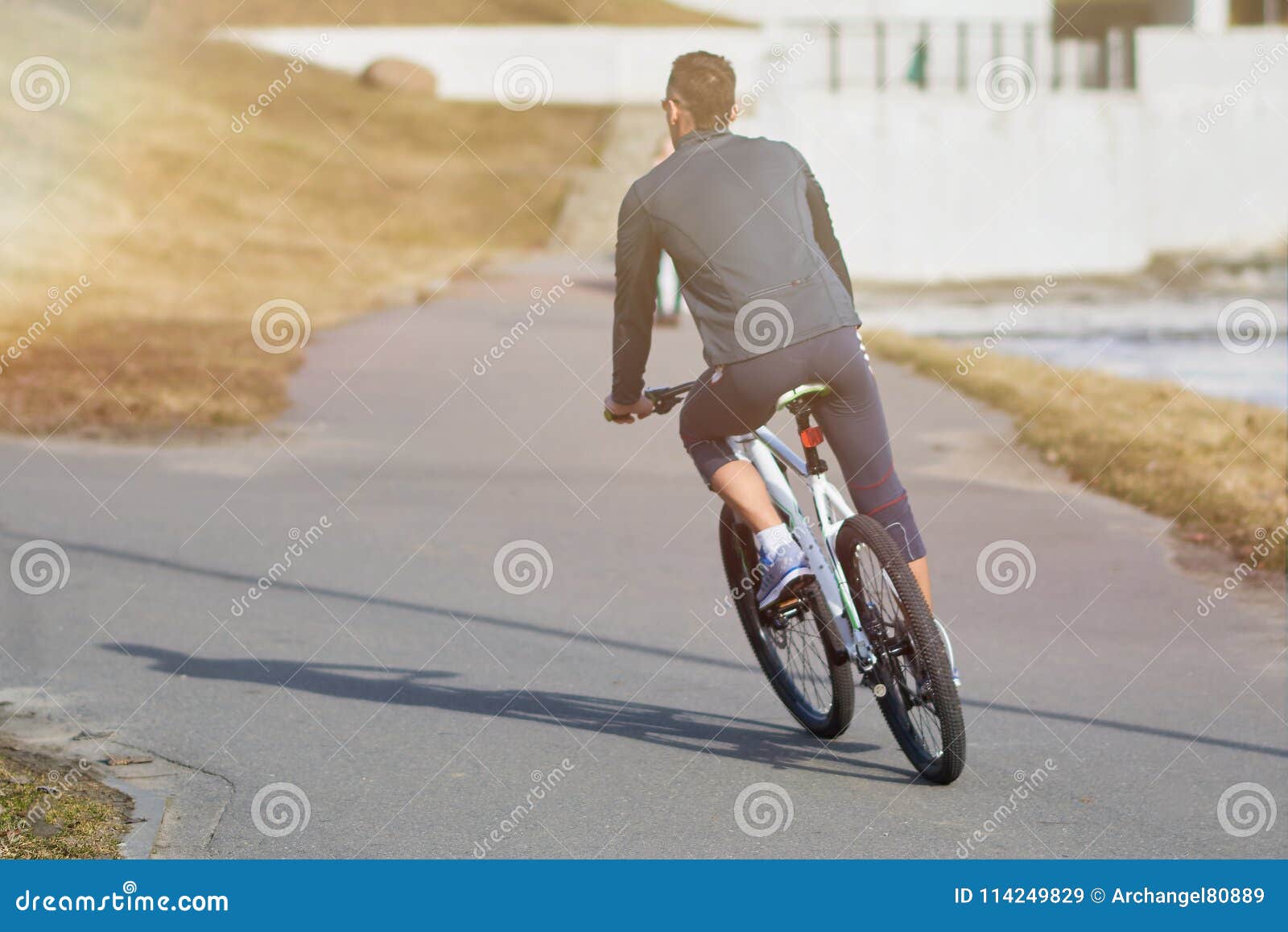 Cyclist from behind stock image. Image of motion, male - 114249829