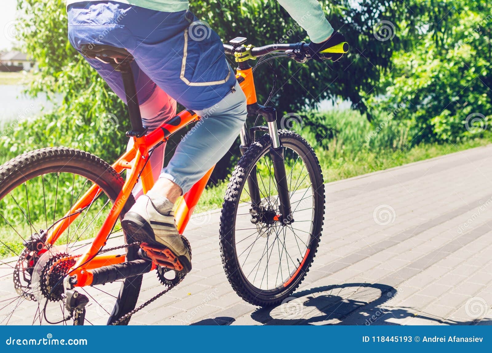 Cyclist on an Orange Bike Riding a Bicycle Path Stock Image - Image of ...