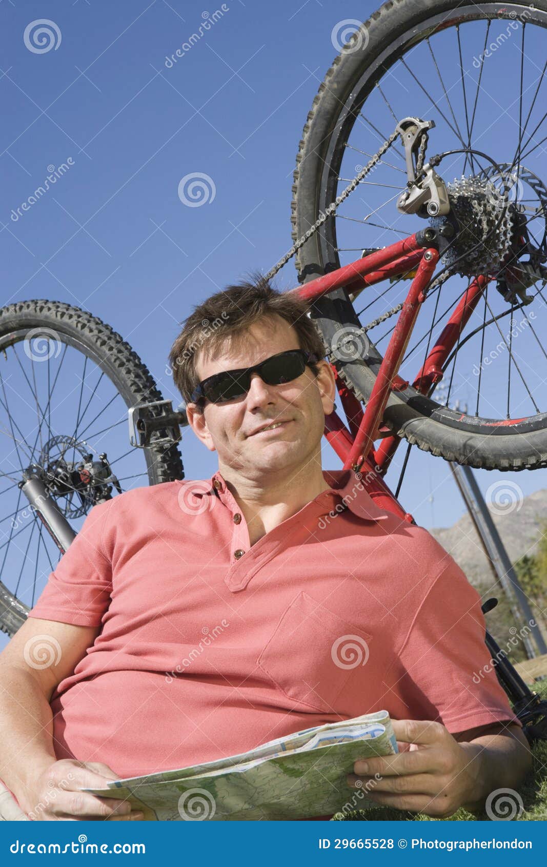 Cyclist with Roadmap Lying in Front of Bicycle Upside Down Stock Photo ...