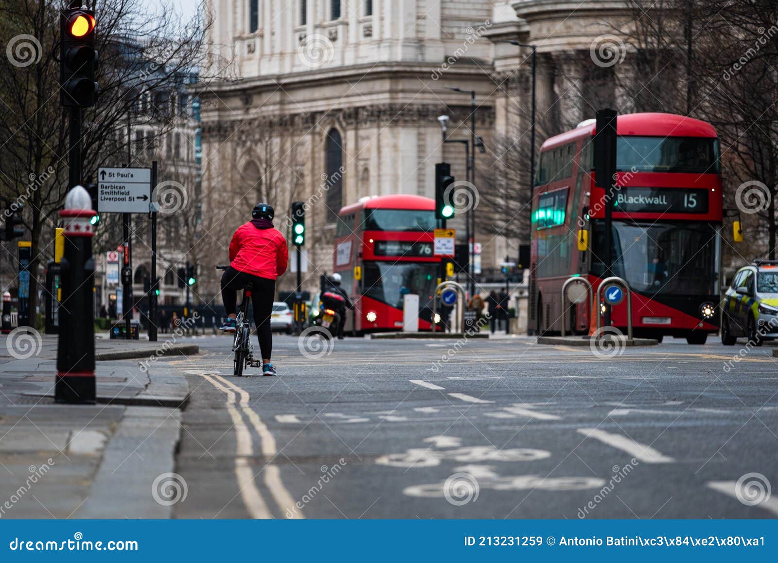 Cyclist Wearing a Red Jacket Waiting for the Traffic Lights on an ...