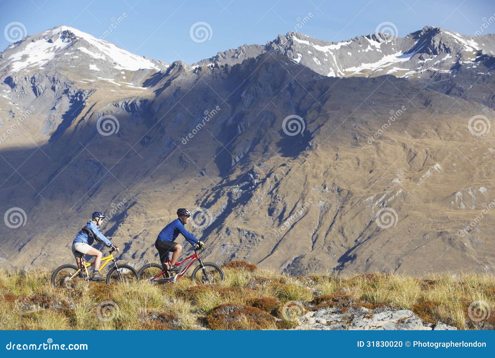 Cyclists Riding Past Mountains Stock Photo - Image of outdoors ...