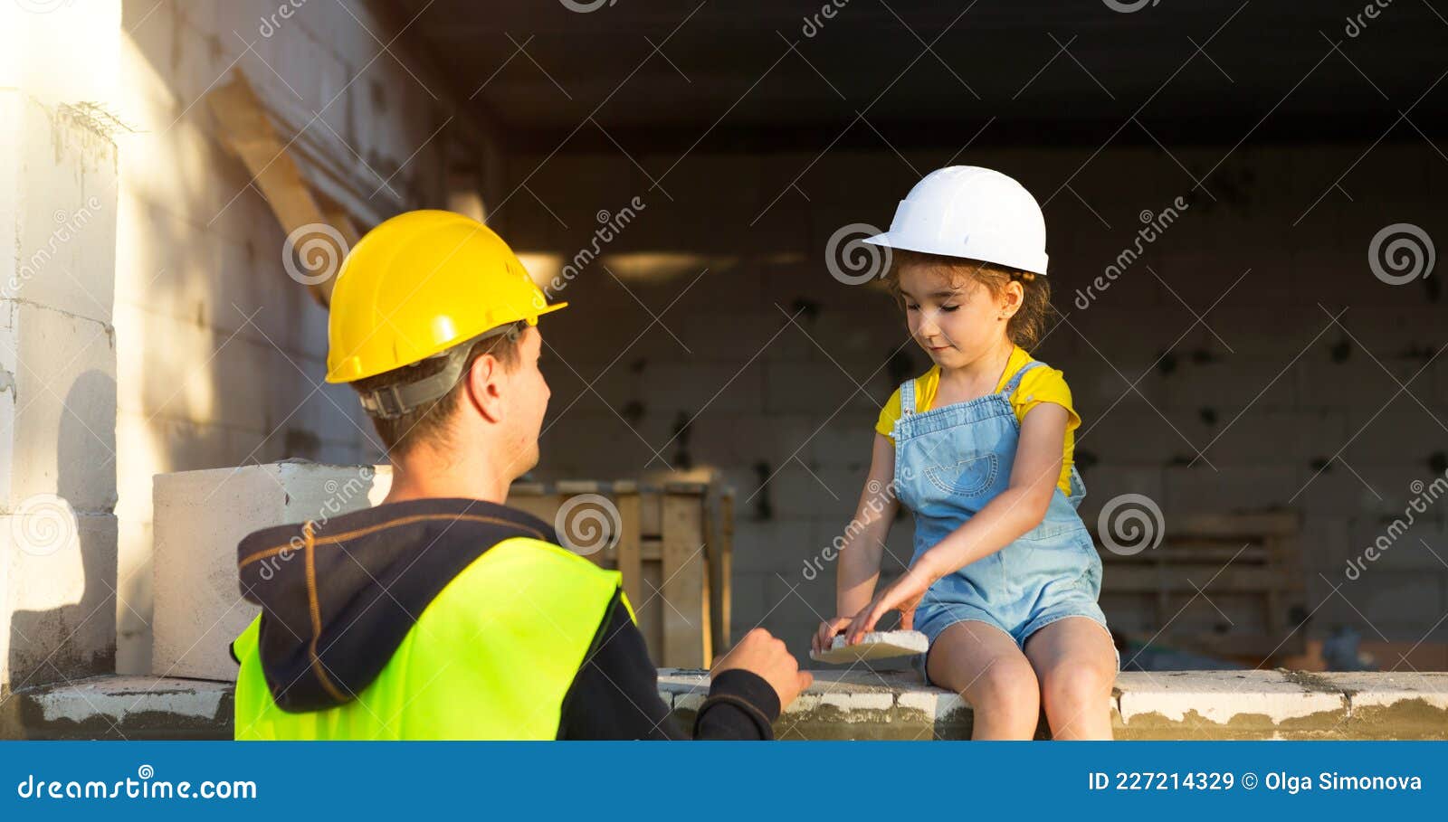 Dad and Daughter are at Construction Site of Their Future Home. the ...