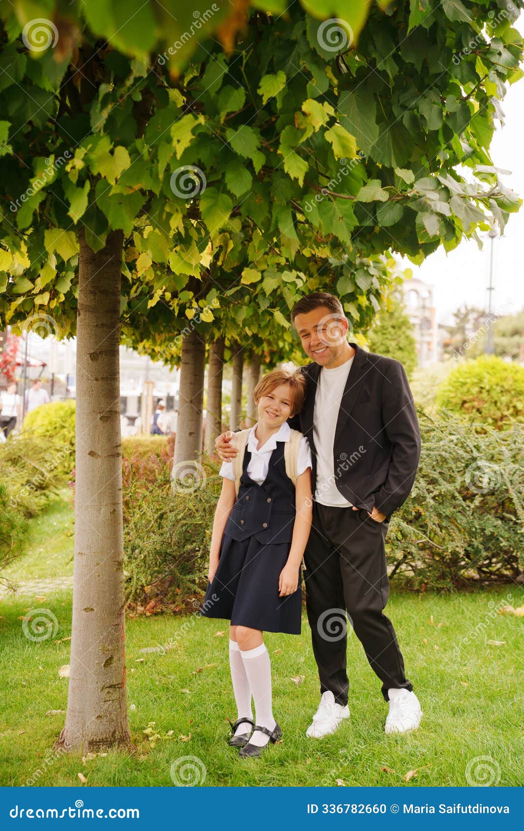 Dad and Daughter in School Uniform on the Lawn Under a Tree. Stock ...