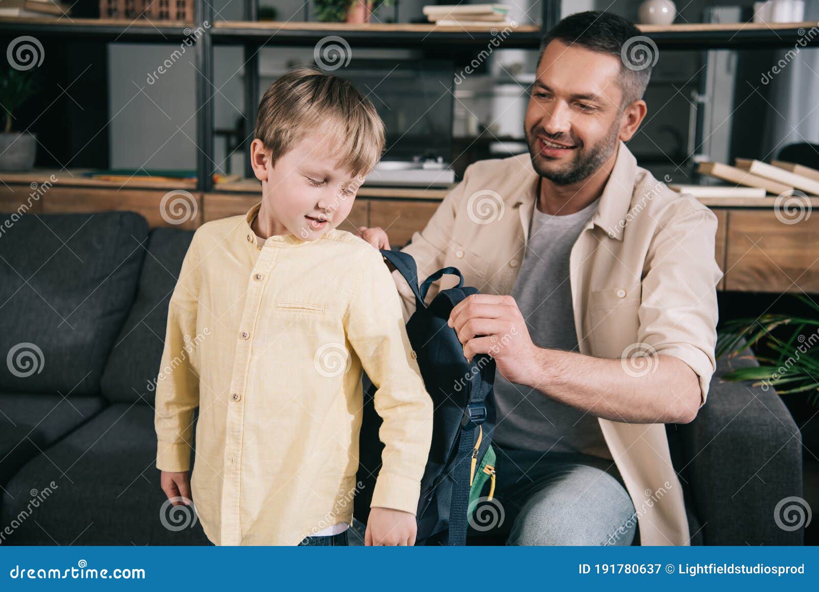 Dad Helping Cute Boy Putting on Backpack at Home Stock Image - Image of ...