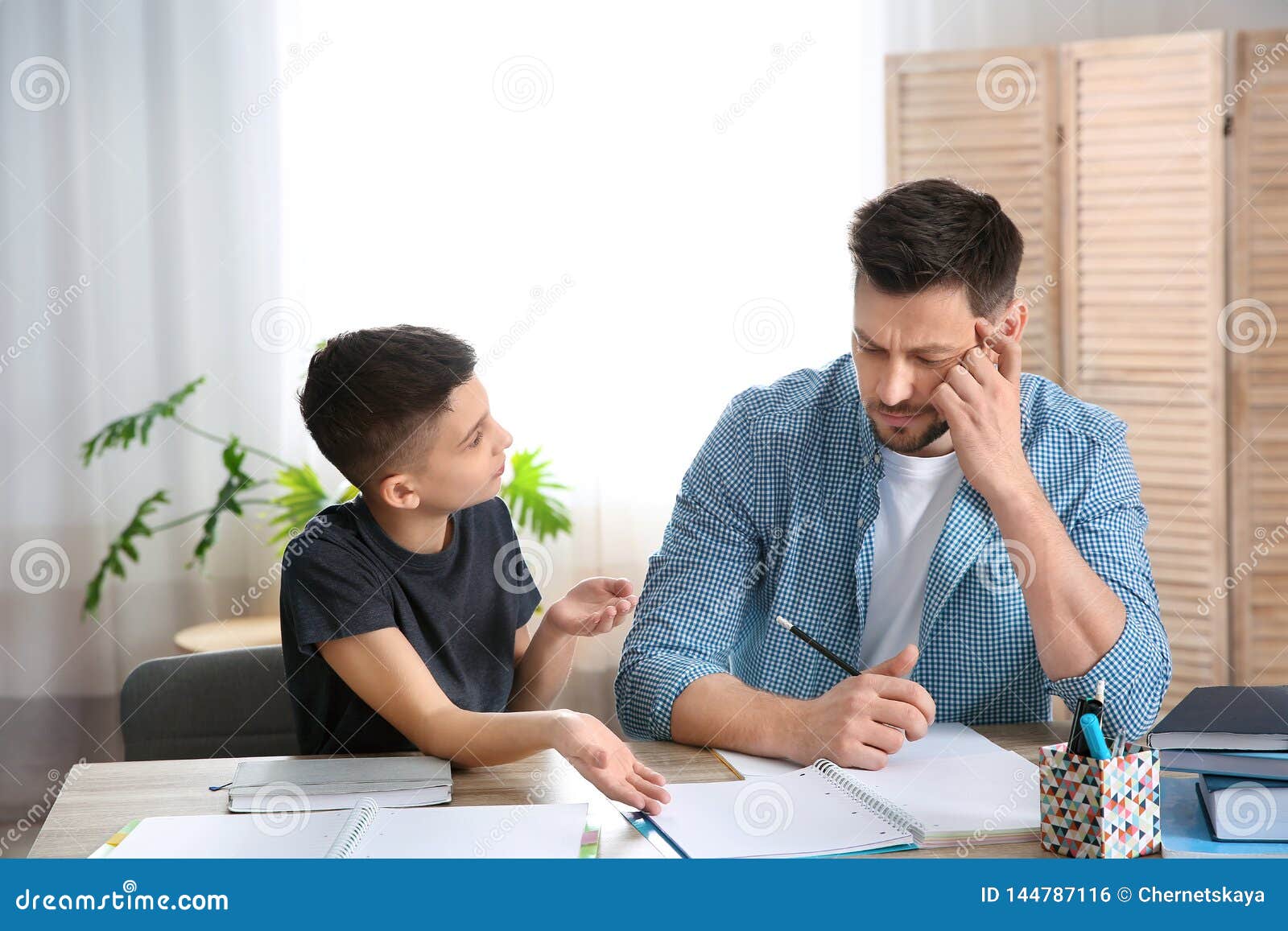 Dad Helping His Son with Homework Stock Photo - Image of child, indoors ...