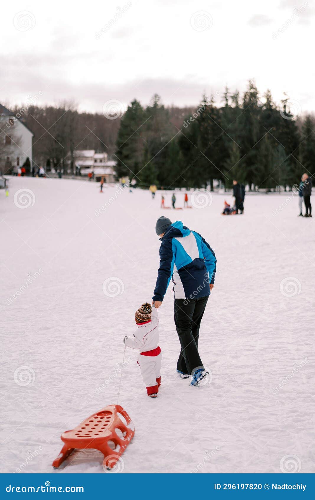 Dad Leads by the Hand a Small Child Pulling a Sled Across a Snowy Plain ...