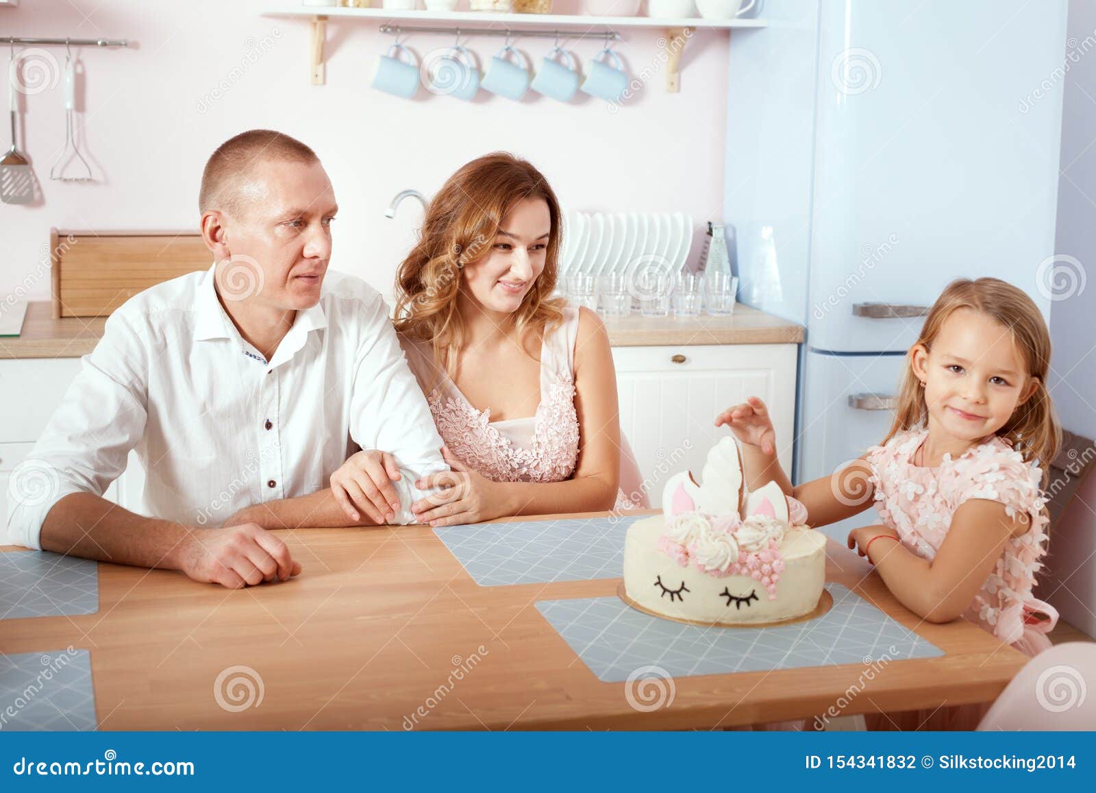 Dad, Mom and Daughter are Sitting in the Kitchen at the Table Stock ...