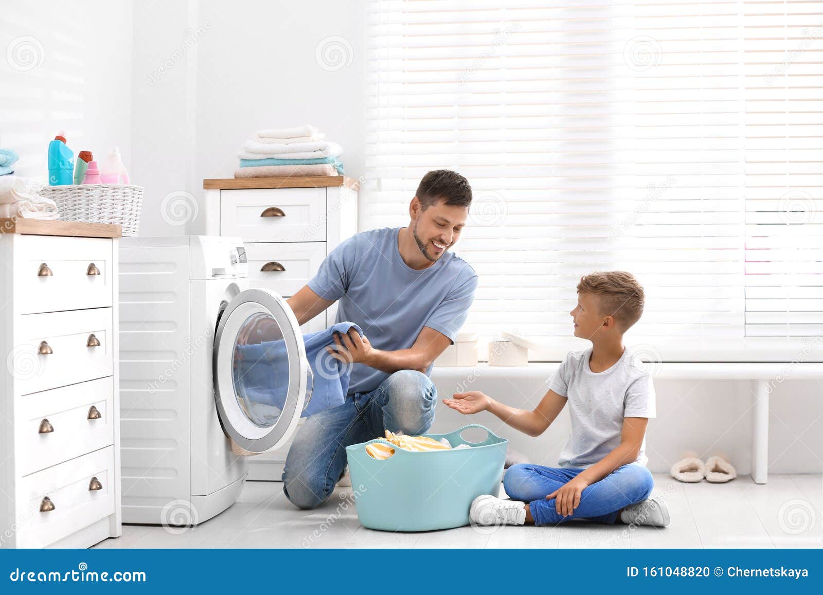 Dad and son doing laundry stock photo. Image of basket - 161048820