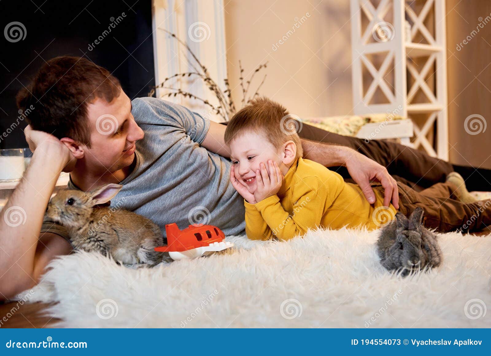 Dad and Son are Playing with the Rabbits at Home. Stock Image - Image ...