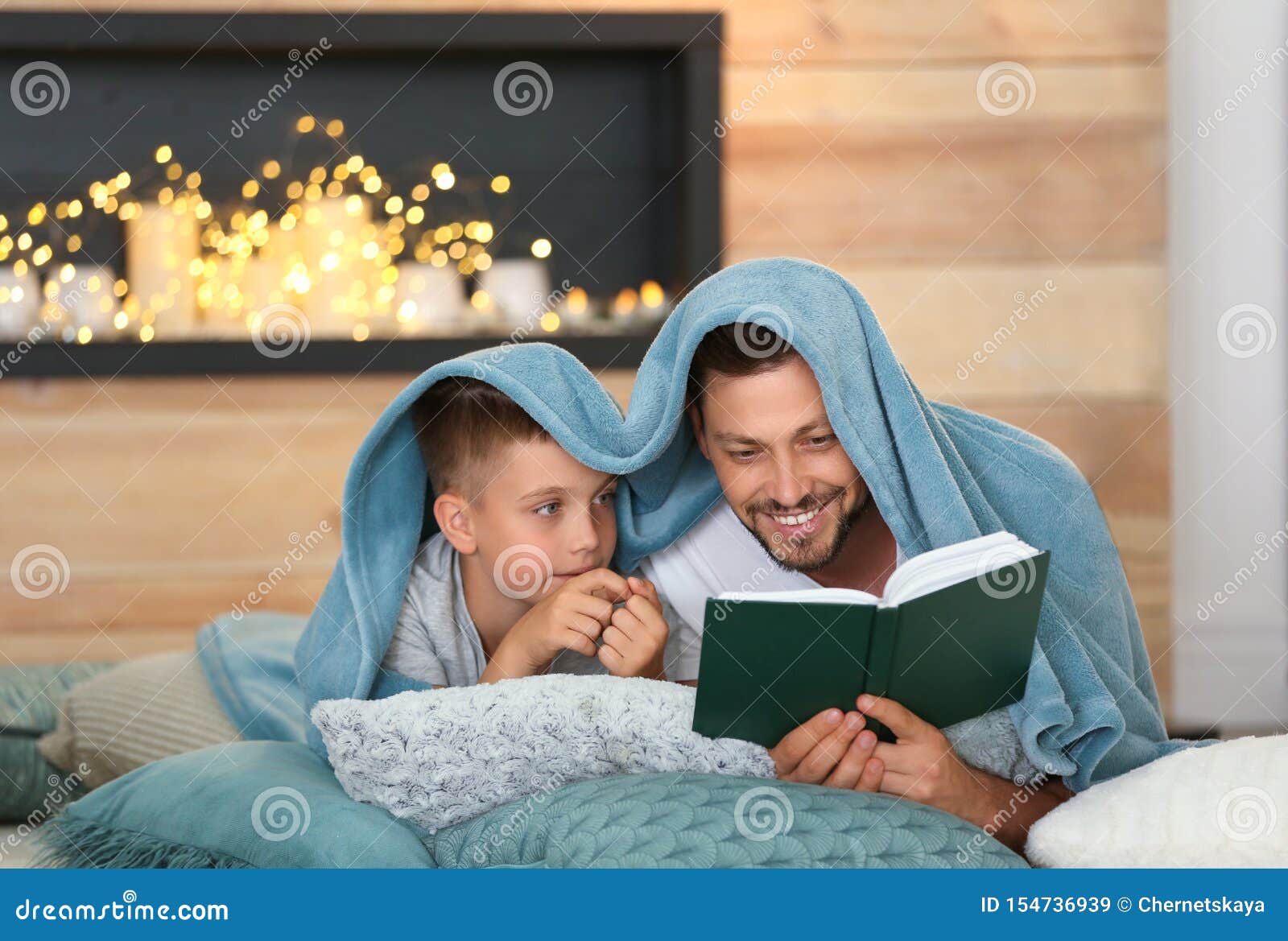 Dad and Son Reading Interesting Book Near Fireplace Stock Image - Image ...