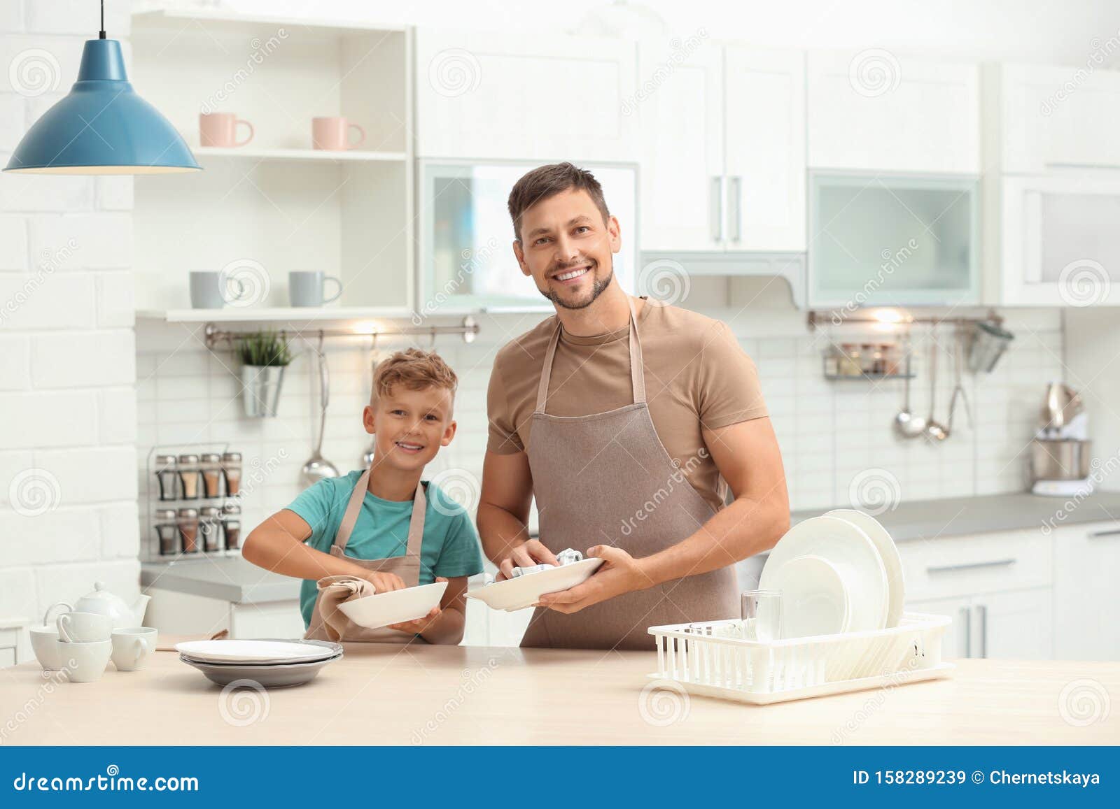 Dad and son wiping dishes stock image. Image of cleaning - 158289239