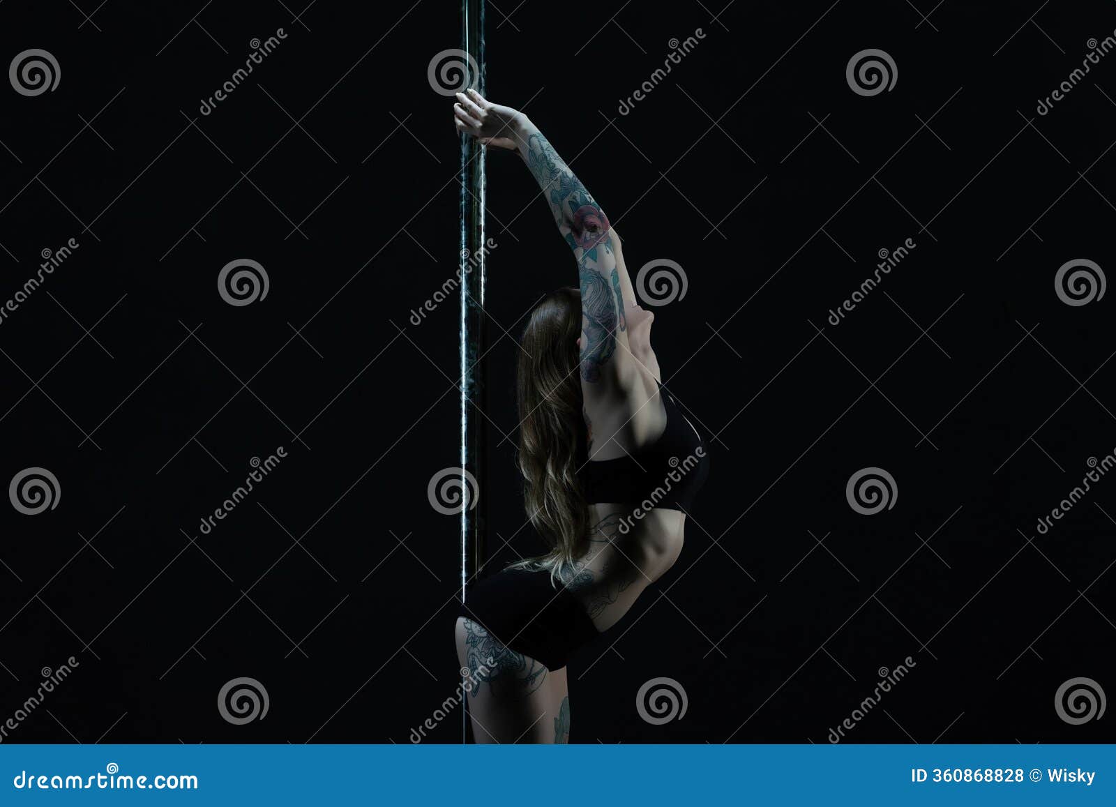Dancer Performs Elegant Routine Around Pole in Dark Studio Setting ...