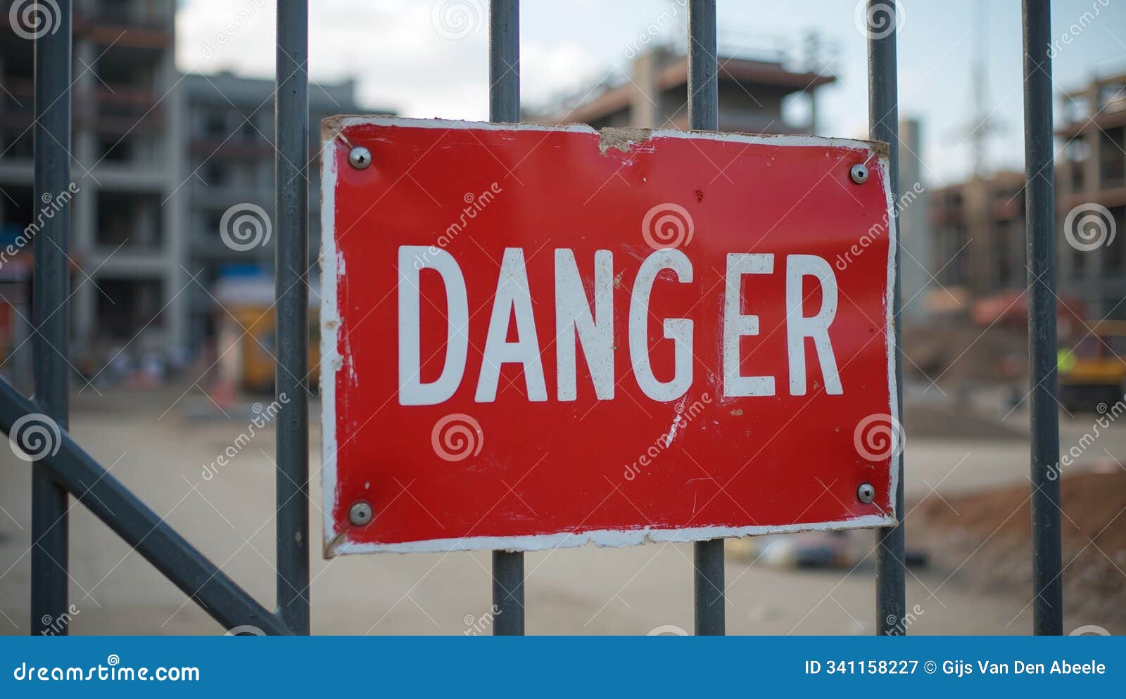 Danger Warning Sign on Metal Gate with Blurry Construction Site Stock ...