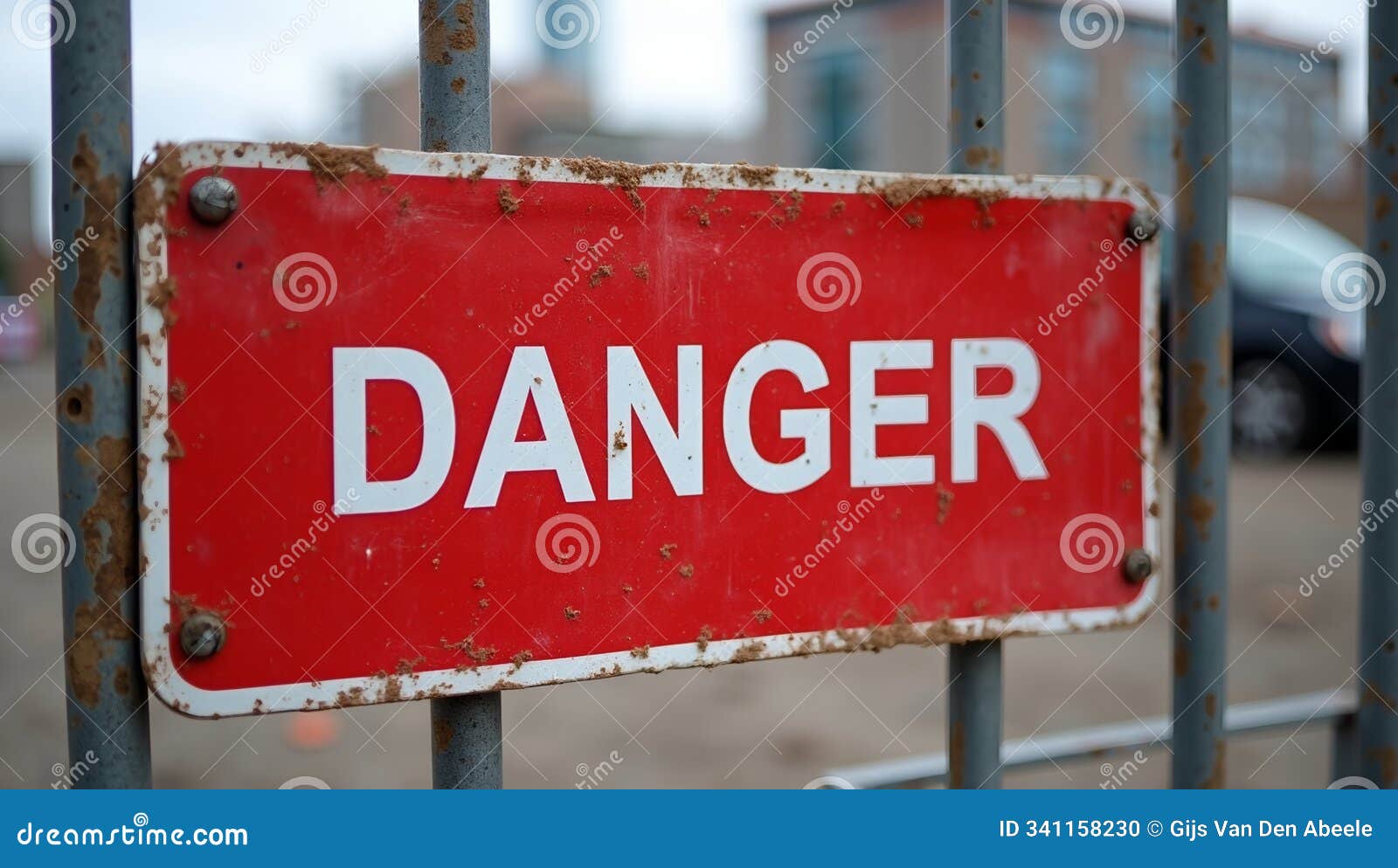 Danger Warning Sign on Metal Gate with Blurry Construction Site Stock ...