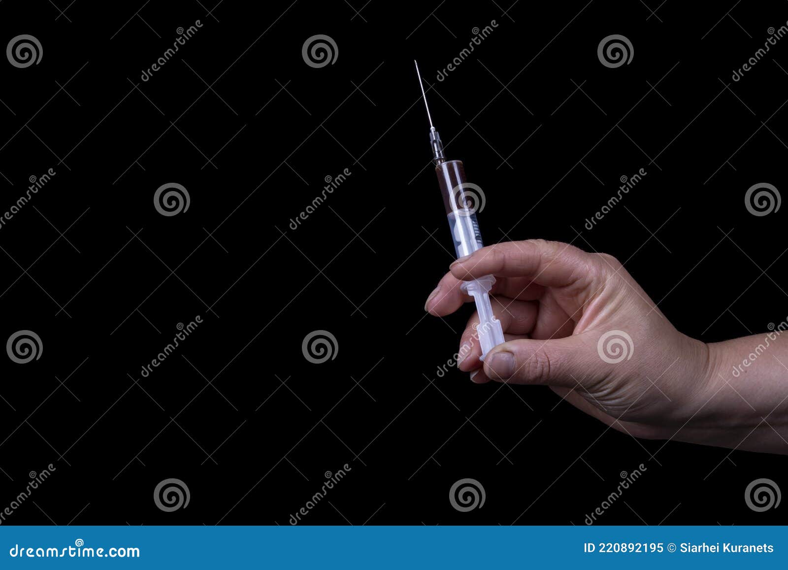 Dark Background. a Human Hand Holds a Syringe with a Dark Liquid in it ...