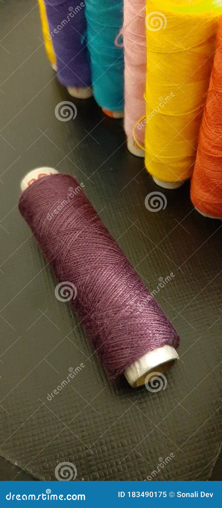 Dark Brown Thread Reel Lying Down on Black Surface and Stacks of Reels ...