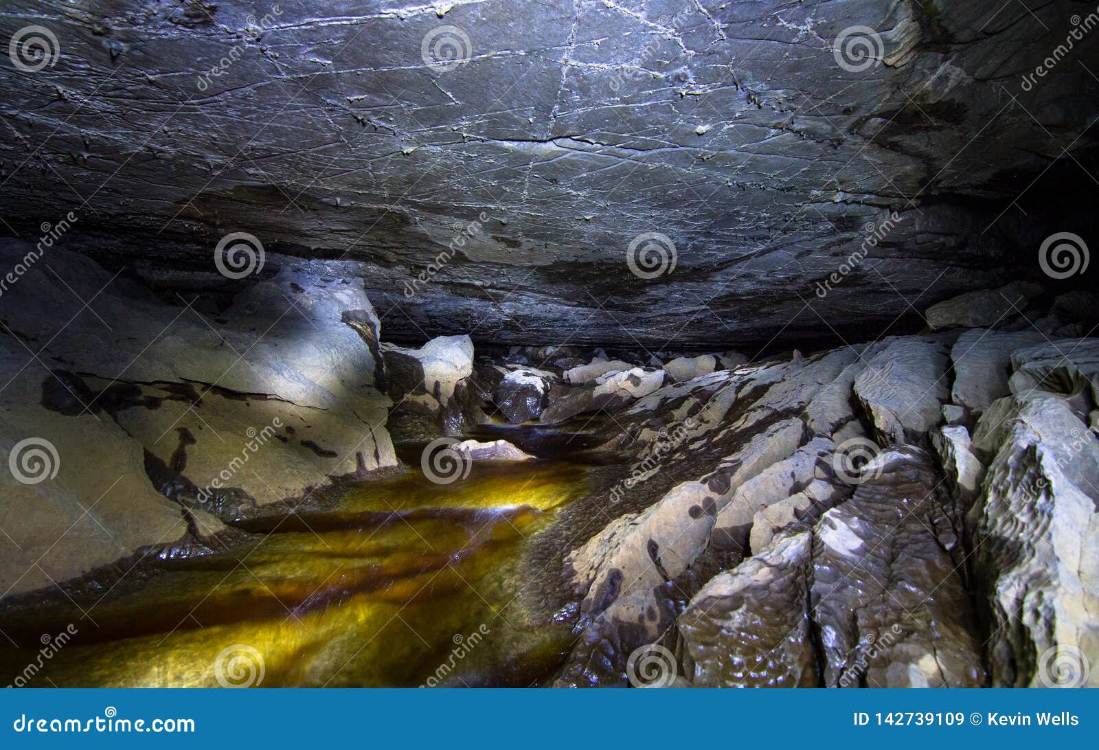 Dark Cave with a Stream Flowing through it Stock Image - Image of ...