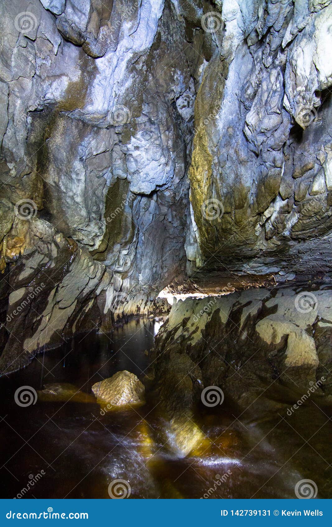 Dark Cave with a Stream Flowing through it Stock Image - Image of ...