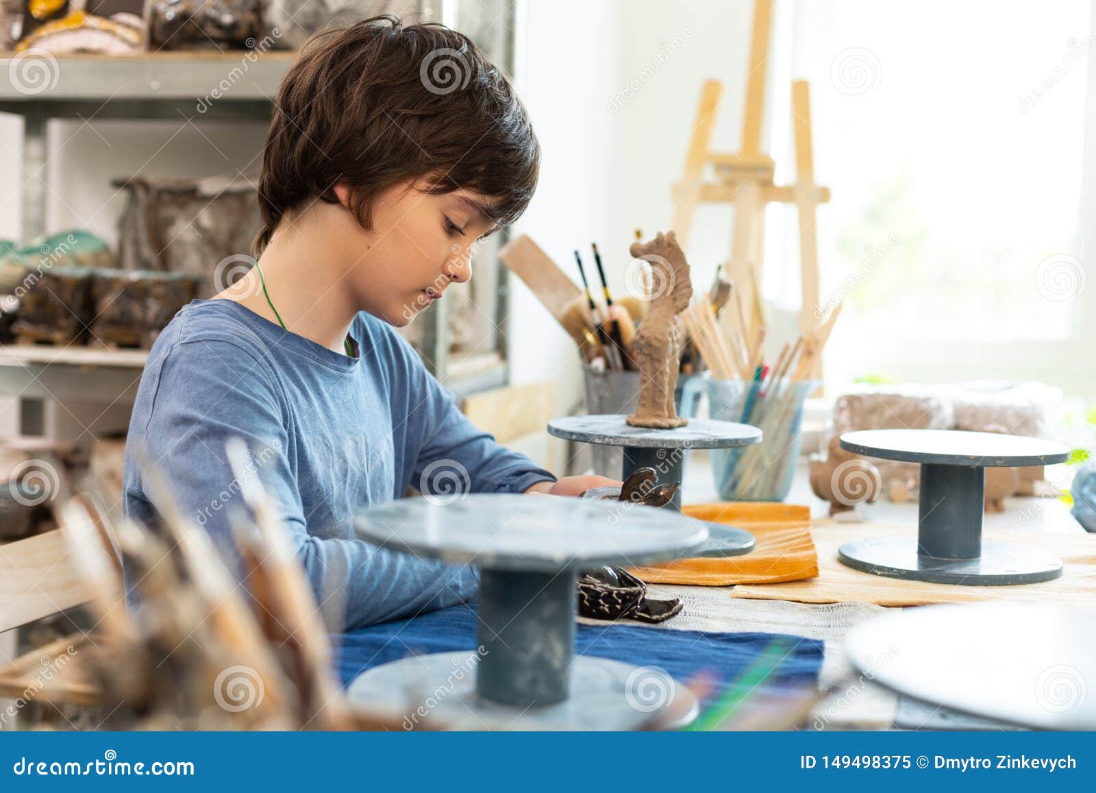 Dark-haired Boy Sitting and Modeling Polymer Clay Figures Stock Image ...