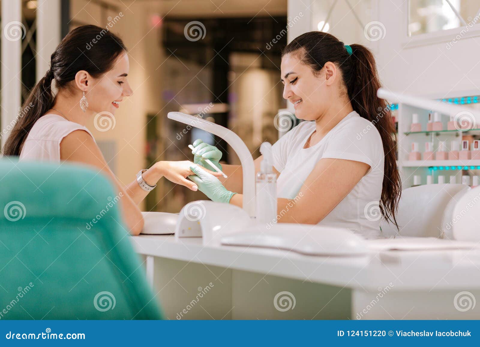 Dark-haired Nail Master with Long Ponytail Using File Making Manicure ...