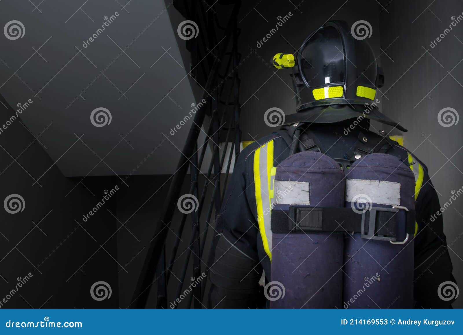 In a Dark Room, Close-up of the Back of a Firefighter in Protective ...