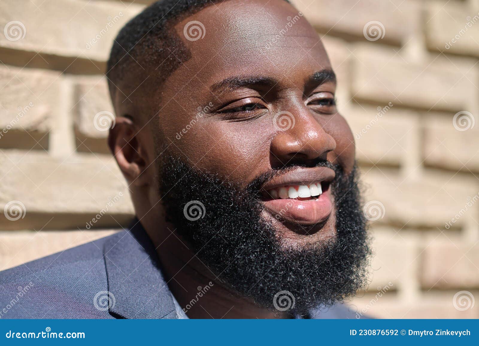 A Dark-skinned Man in a Suit Standing Near the Brick Wall Stock Photo ...
