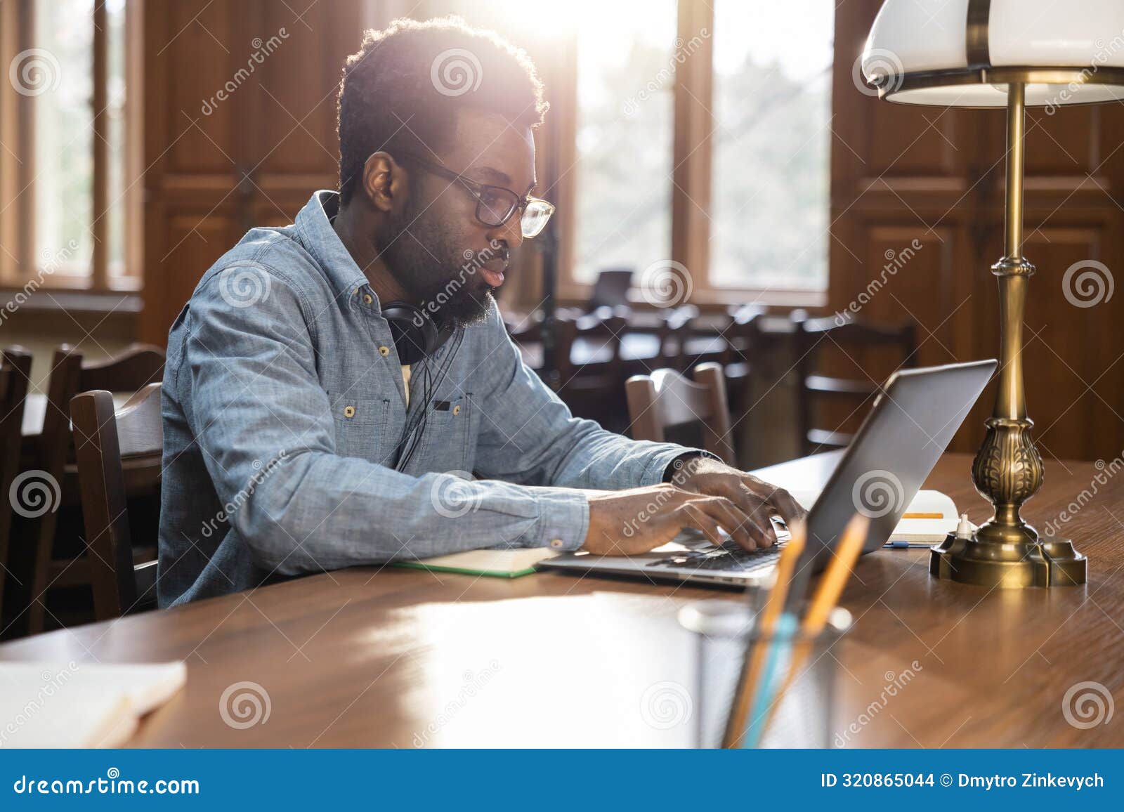 Dark-skinned Young Man Sitting at the Laptop in the Library Stock Photo ...