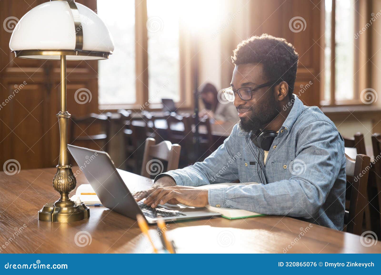 Dark-skinned Young Man Sitting at the Laptop in the Library Stock Photo ...
