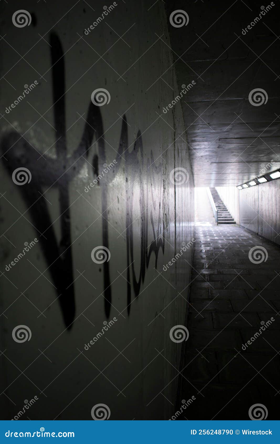 Dark Underpass with Light at the End of the Tunnel and Graffiti on a ...