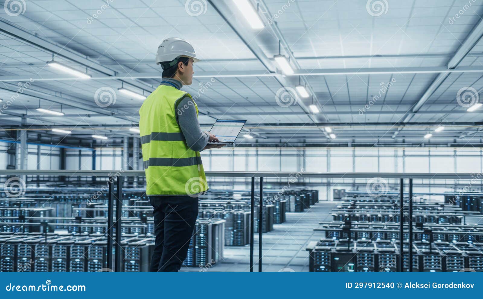 Data Center Engineer in High Visibility Vest Using Laptop Computer ...