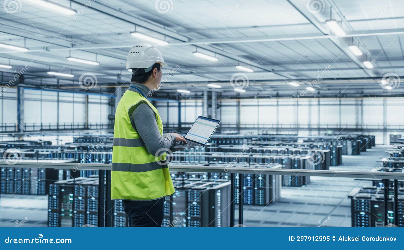 Data Center Engineer in High Visibility Vest Using Laptop Computer ...