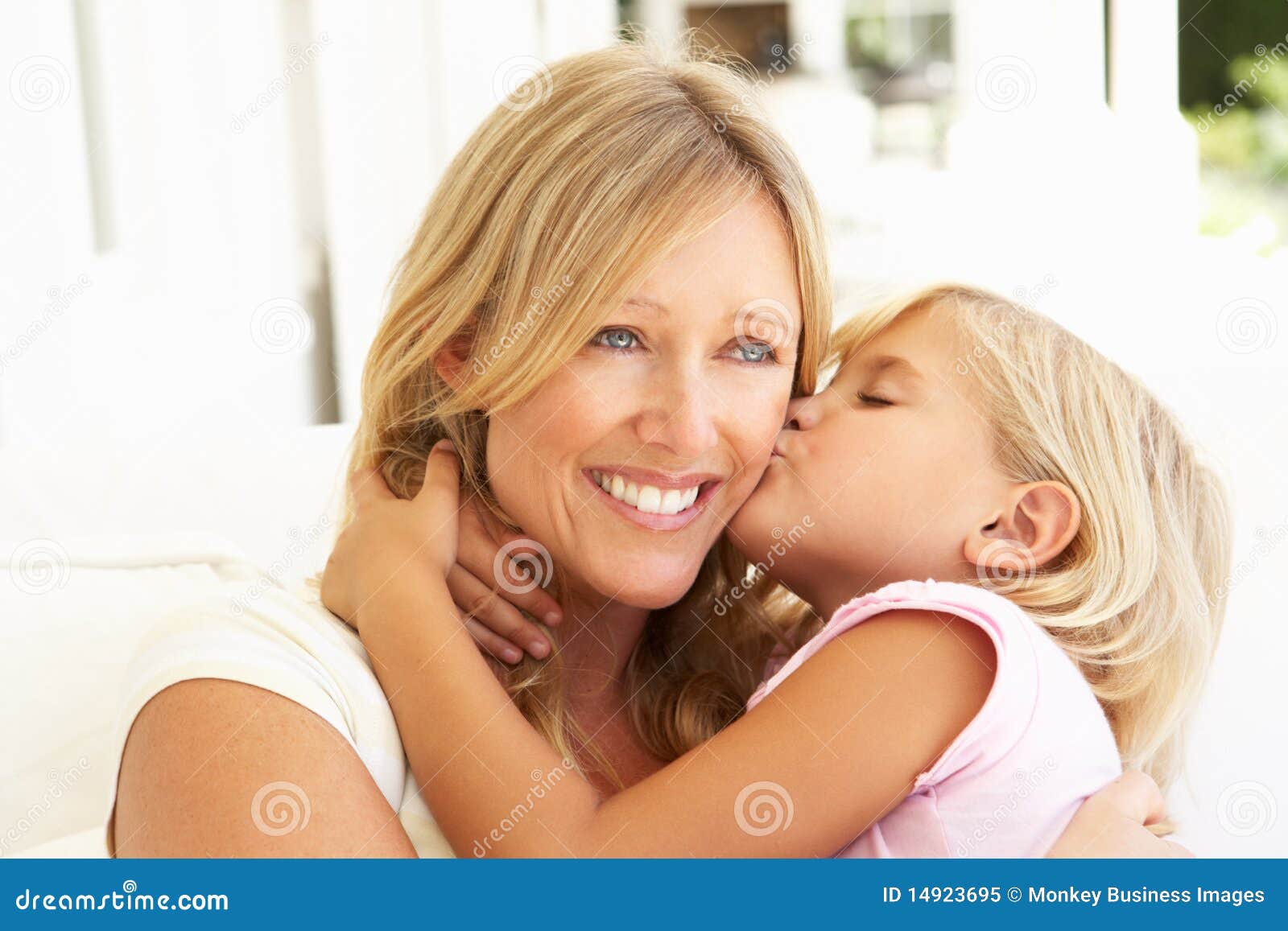 Daughter Giving Mother Kiss Relaxing On Sofa Stock Image Image Of