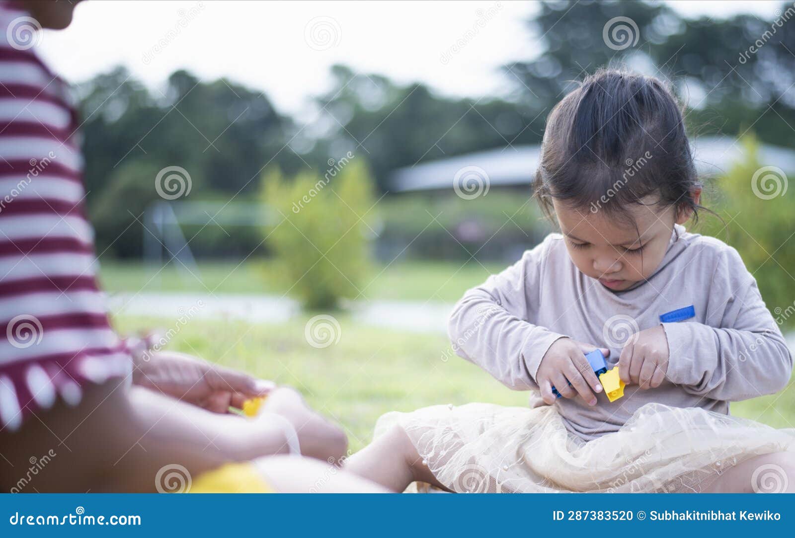 Daughter and Mother Playing with Legos on the Front Yard. Concept of ...