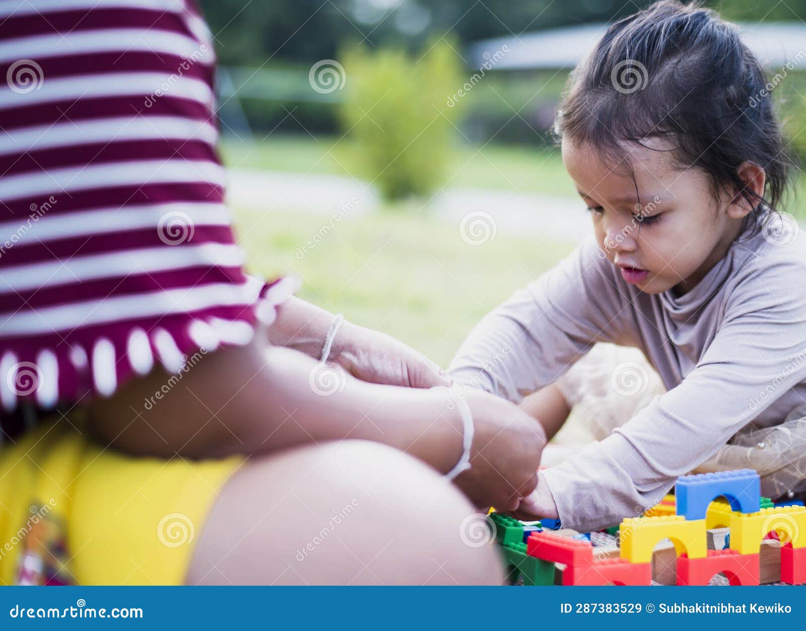 Daughter and Mother Playing with Legos on the Front Yard. Concept of ...