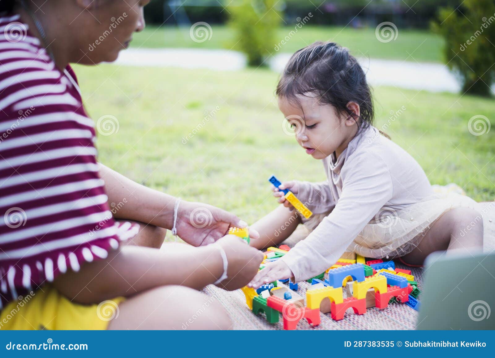 Daughter and Mother Playing with Legos on the Front Yard. Concept of ...