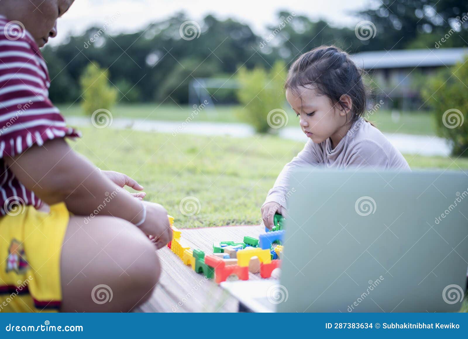 Daughter and Mother Playing with Legos on the Front Yard. Concept of ...