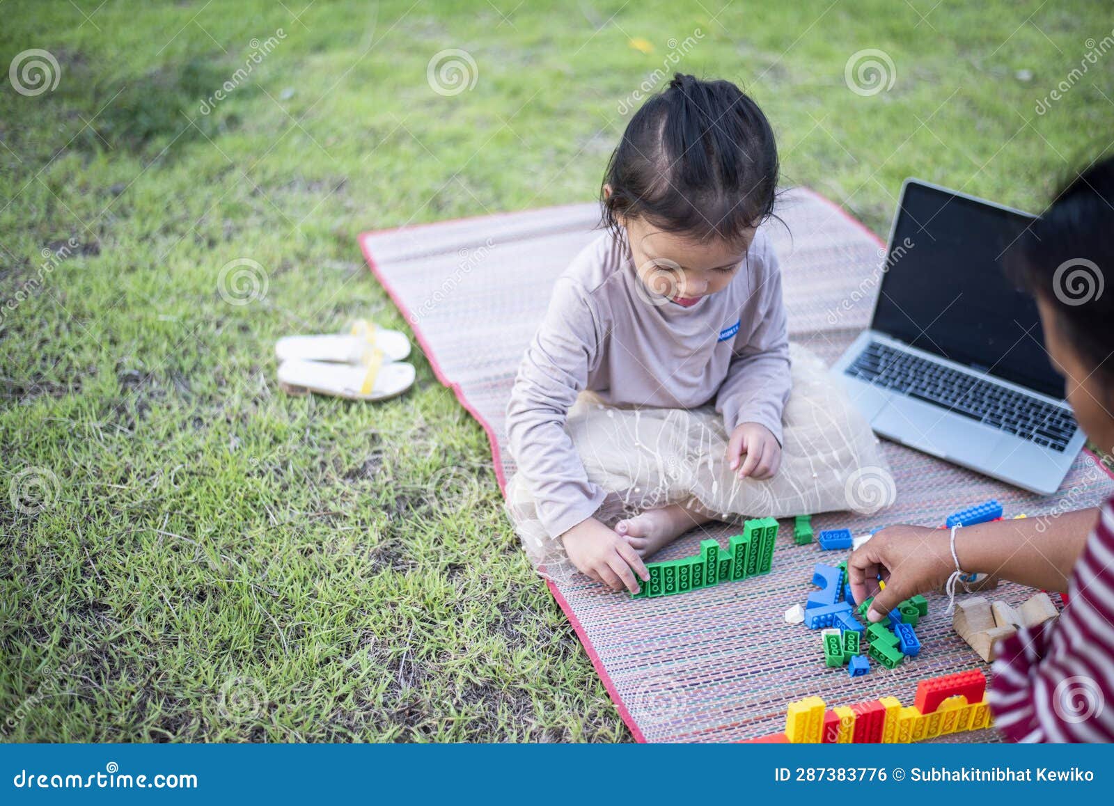 Daughter and Mother Playing with Legos on the Front Yard. Concept of ...